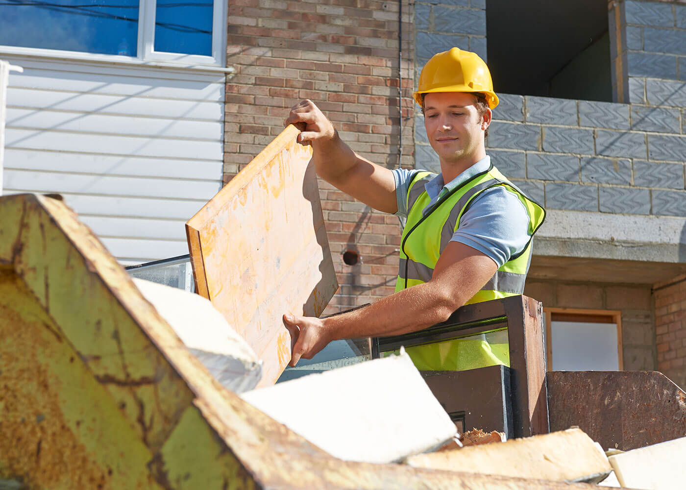 man-putting-waste-into-skip - Tiger Skip Hire Mirfield